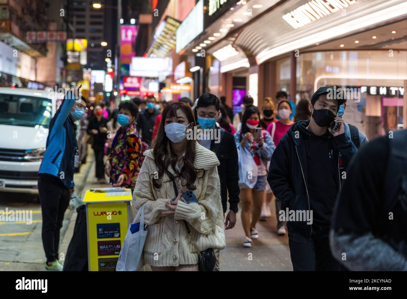 People wearing masks walk on Sai Yeung Choi South street in Mongkok, in ...