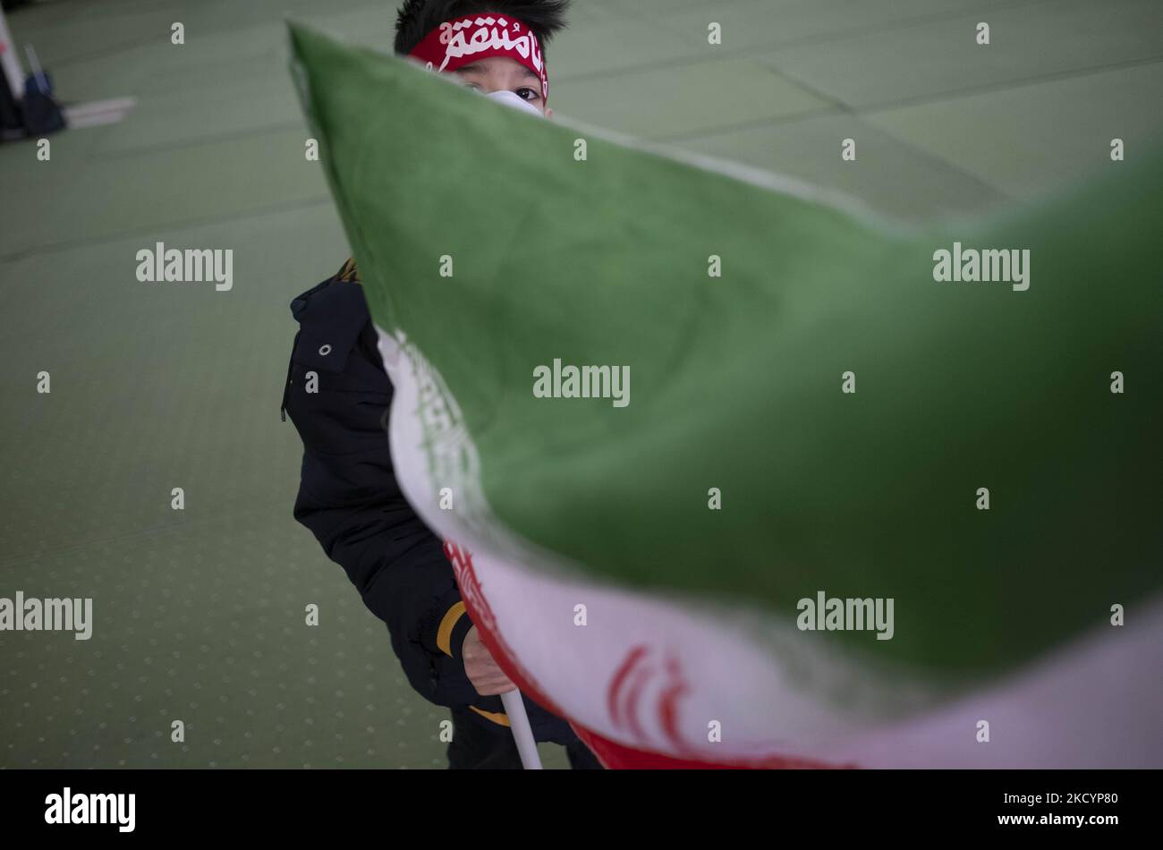 An Iranian young boy waves an Iran flag while attending a ceremony to ...