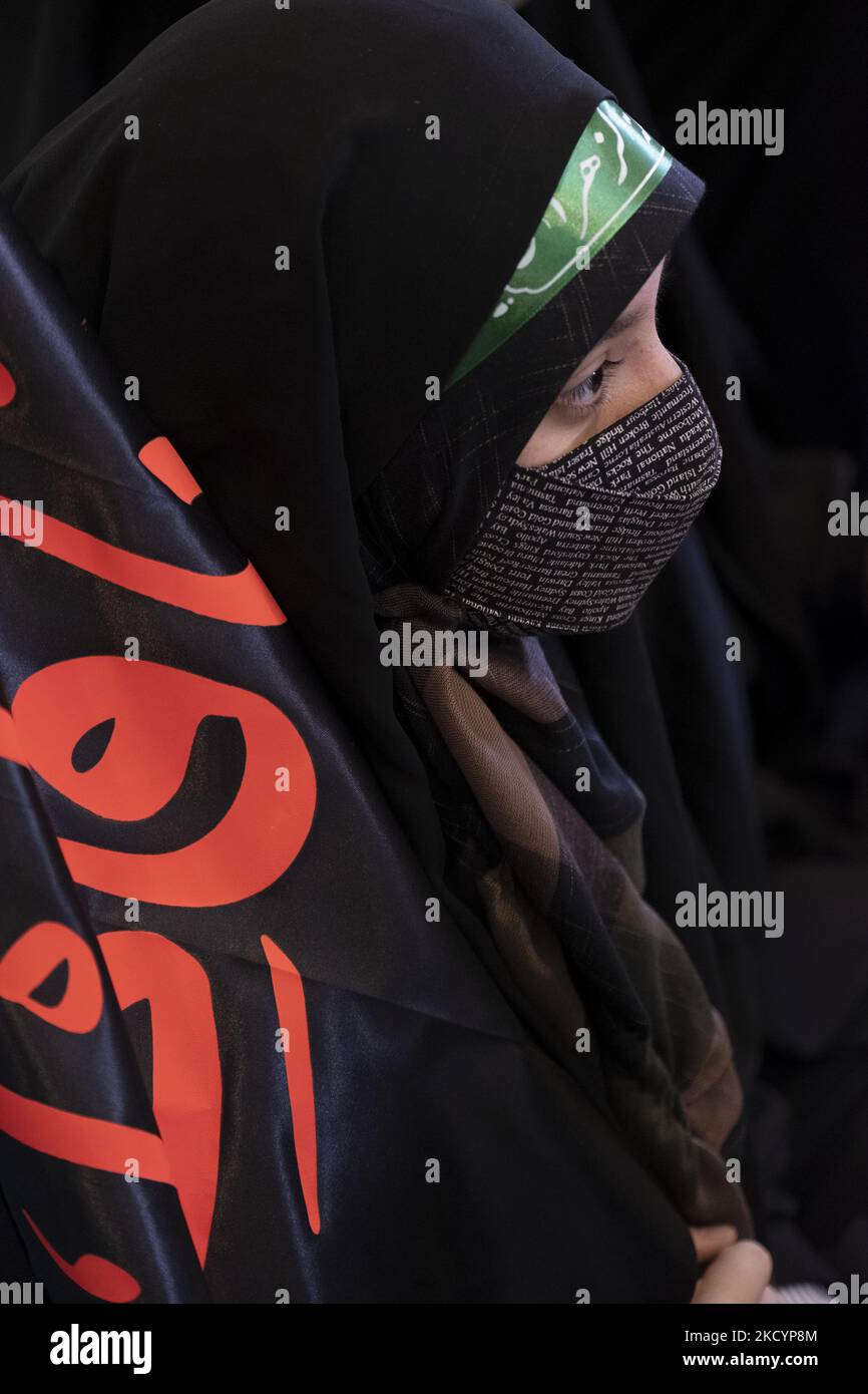 An Iranian young girl wearing a religious headband attends a ceremony ...