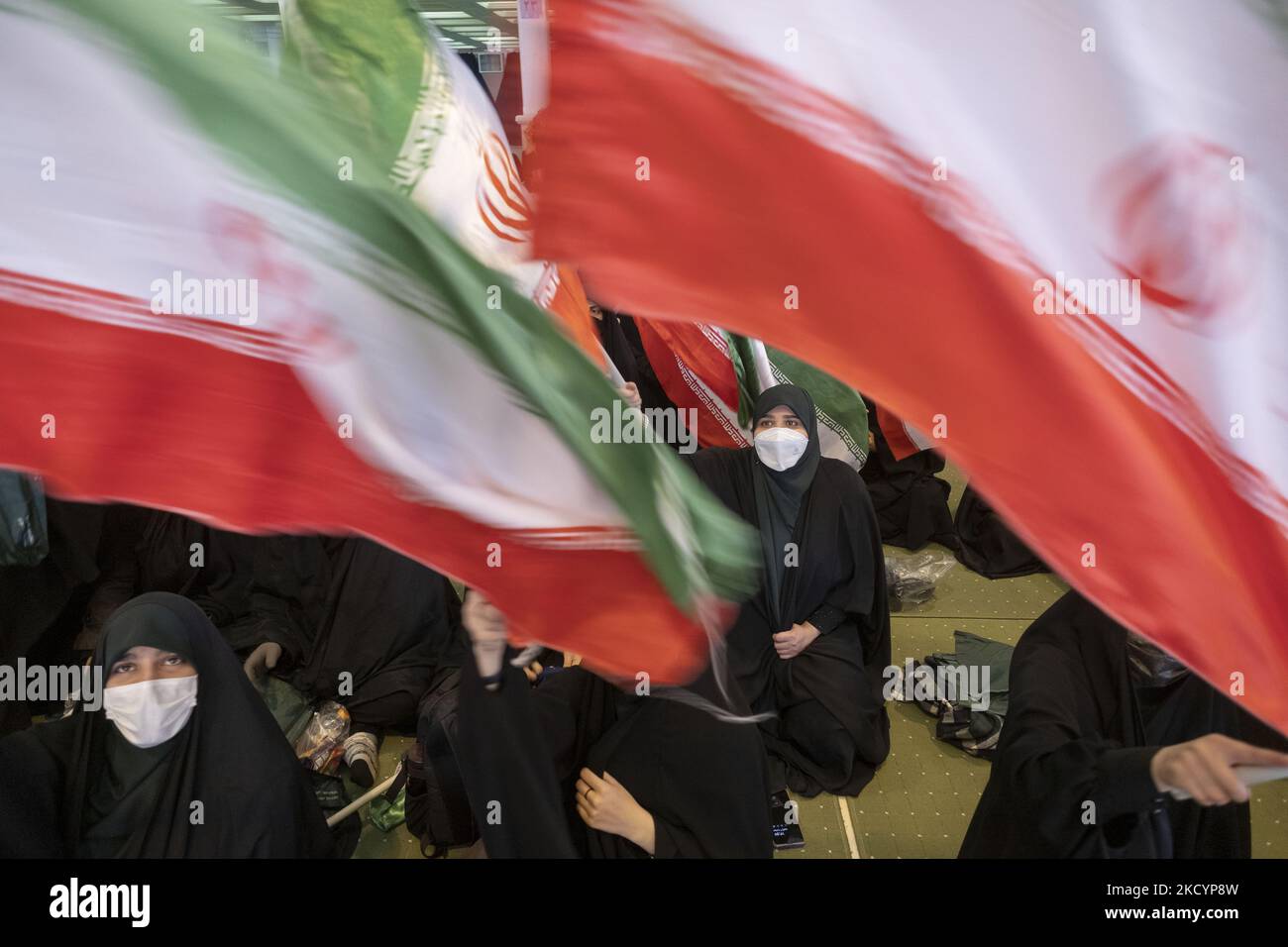 Iranian veiled women wave Iran flags during a ceremony to mark the ...
