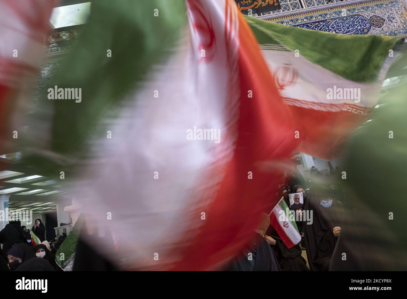 Iranian veiled women wave Iran flags as a woman holds a portrait of ...