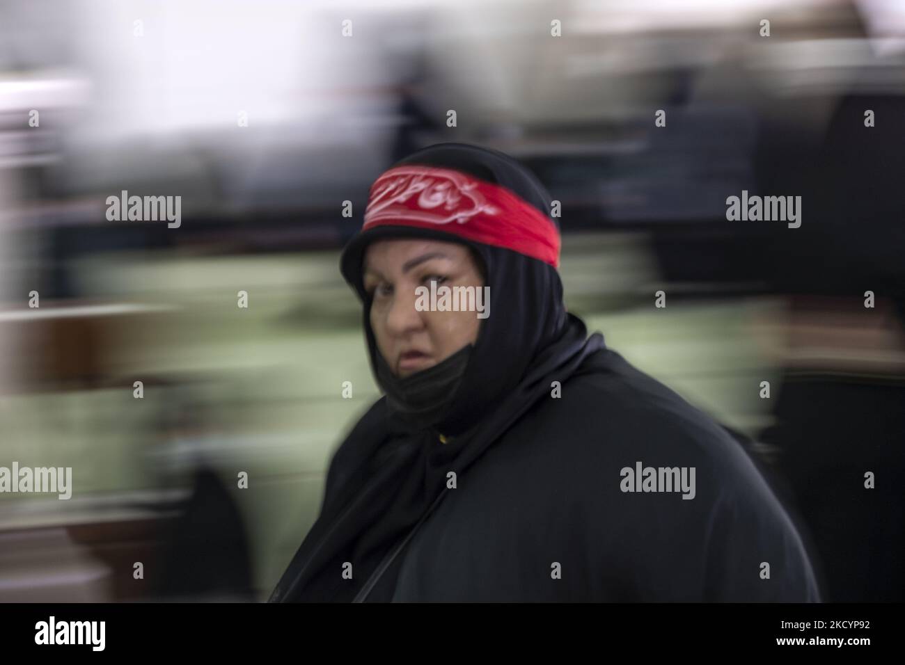 An Iranian woman wearing a religious headband looks on as she attends a ...