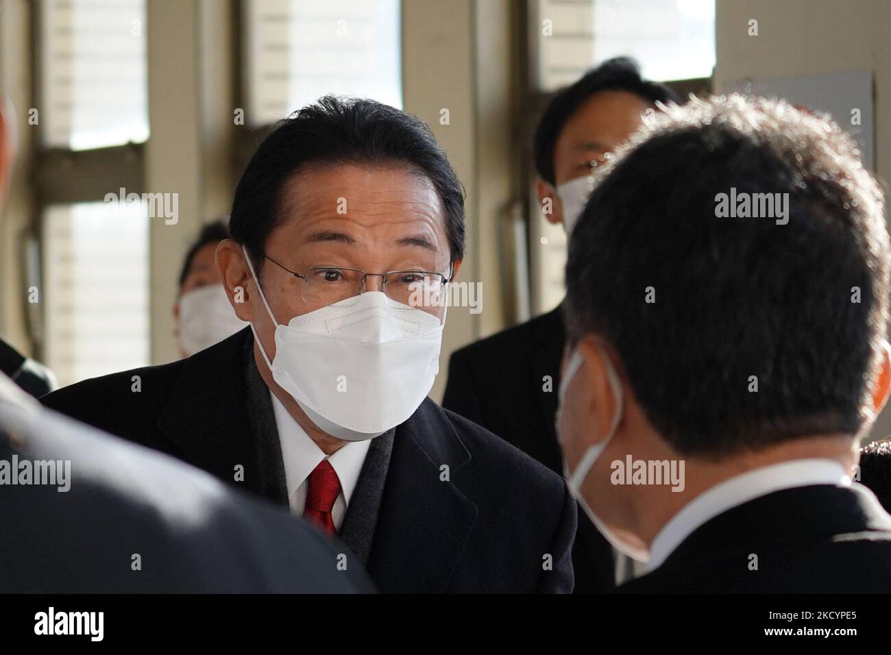 Japan’s Prime Minister Fumio Kishida wearing a face mask greets local ...