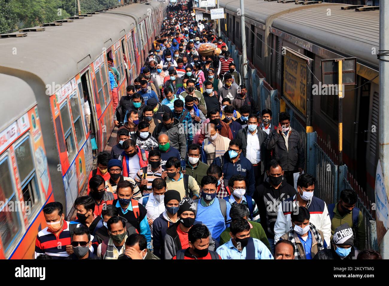 Commuters gather along a railway platform after stepping out from a ...