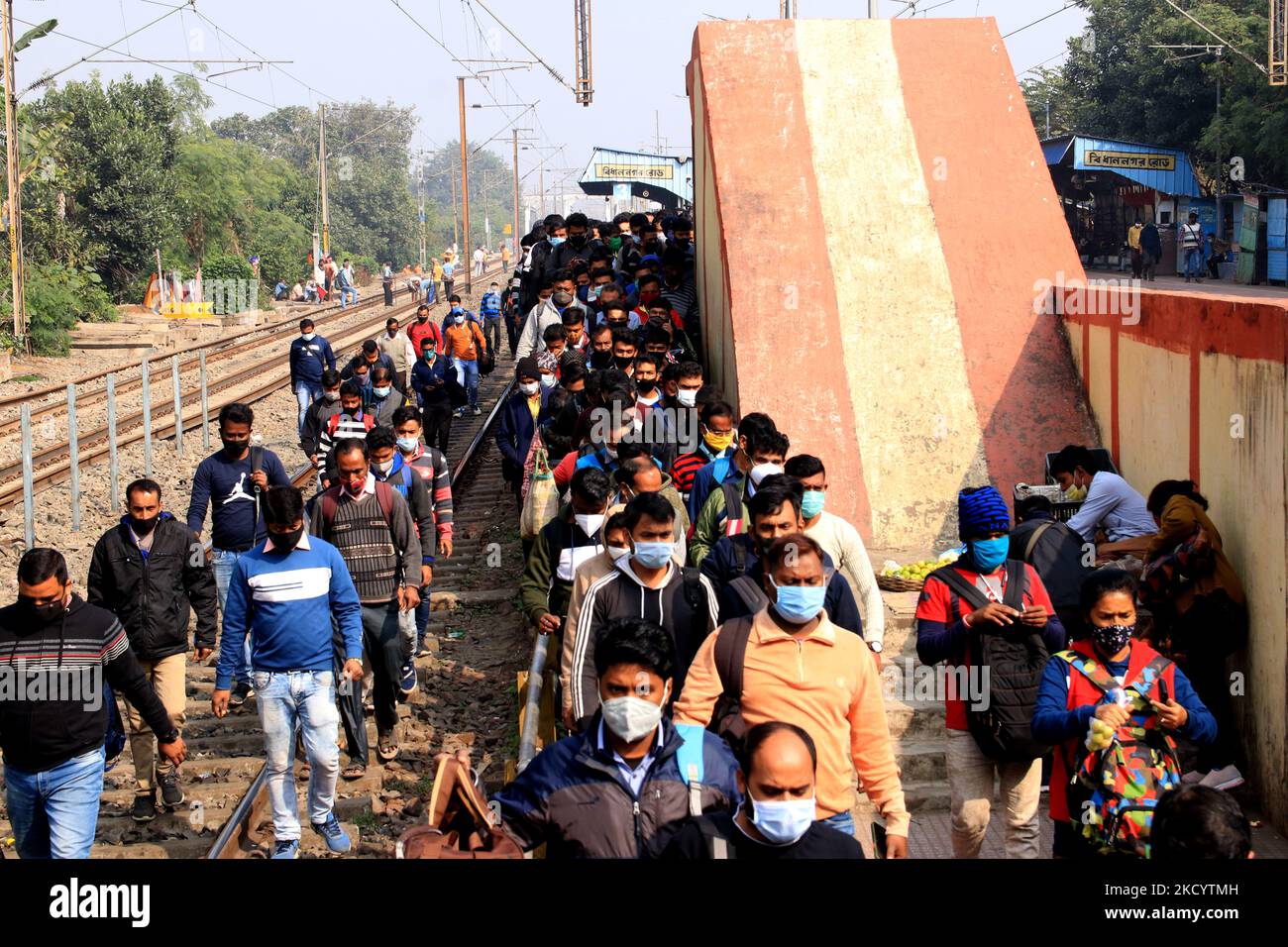 Commuters gather along a railway platform after stepping out from a ...