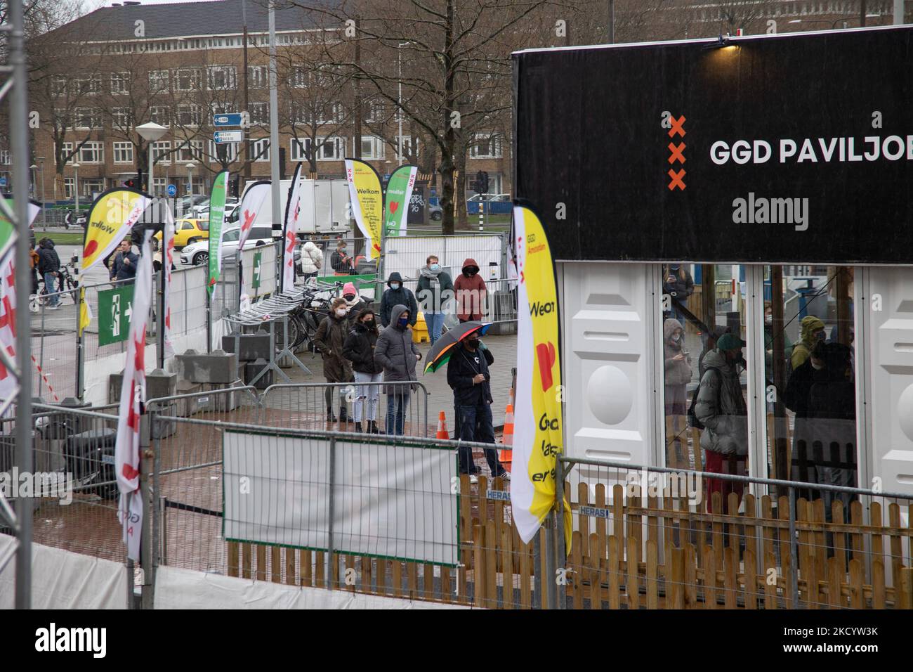People wearing facemasks wait outside of a GGD Paviljoen Amsterdam ...