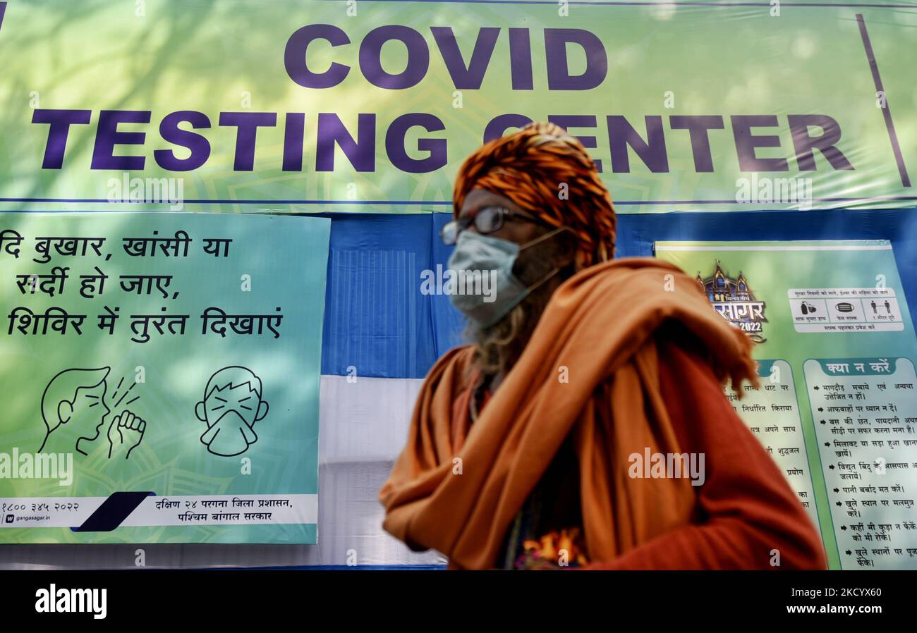 A sadhu wears a mask walks past a covid testing center amid coronavirus ...