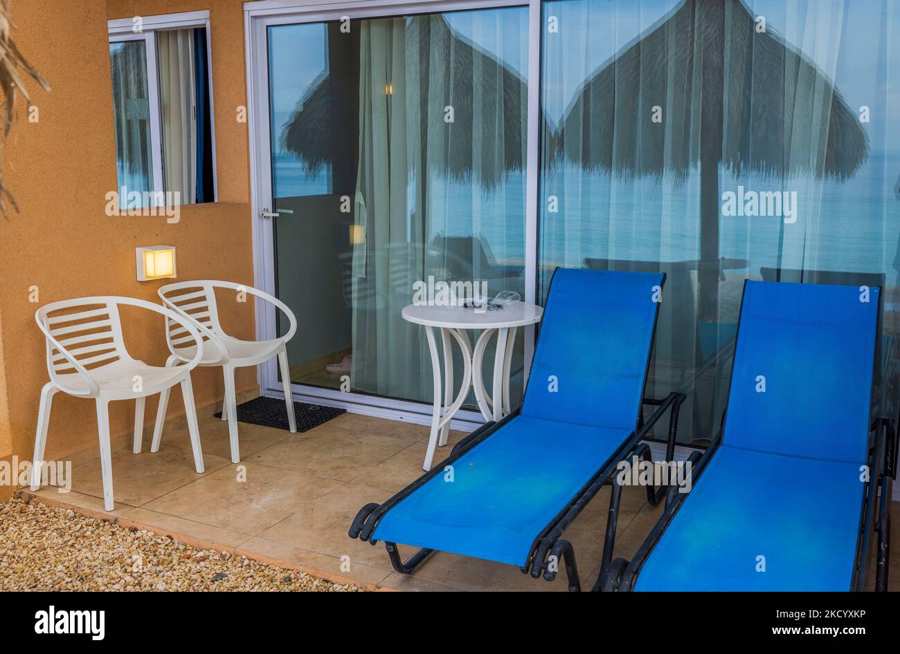 Close up view of hotel patio with sun beds and reflection in window of ...