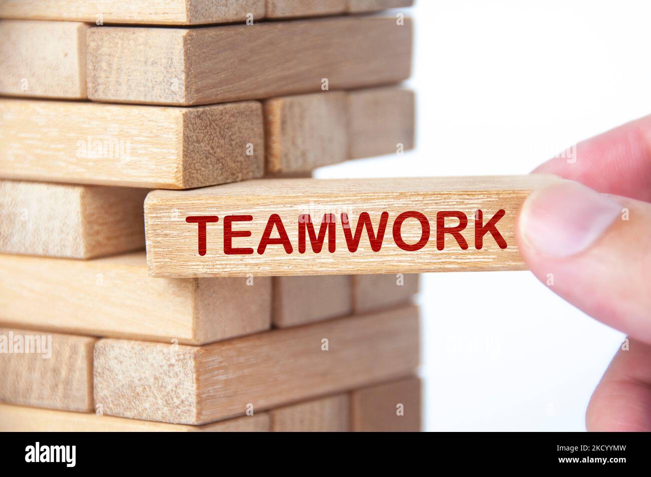 Hand putting a wooden block with text TEAMWORK. Team work concept Stock Photo - Alamy