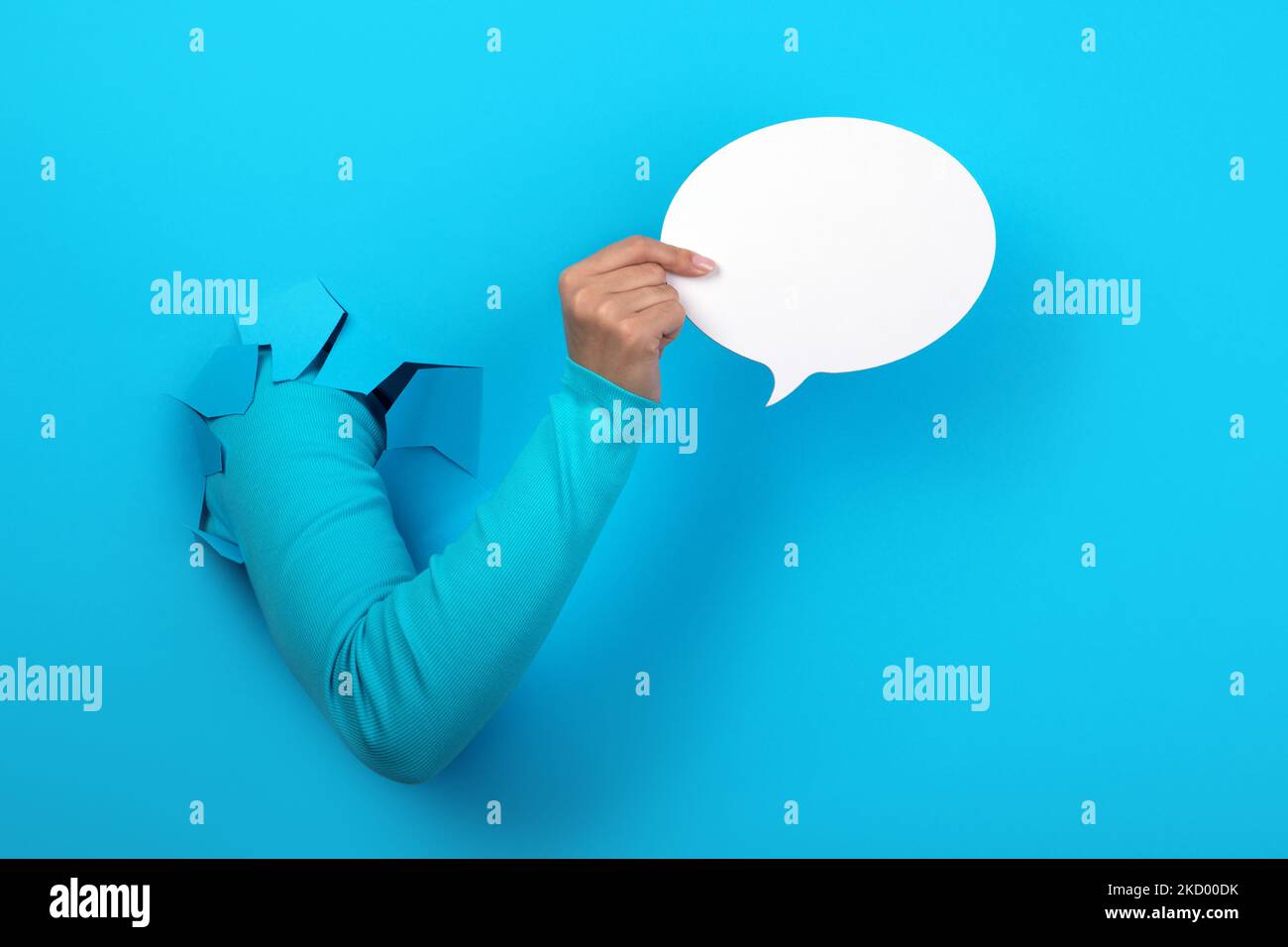 Talk bubble speech icon in hand over blue background Stock Photo - Alamy