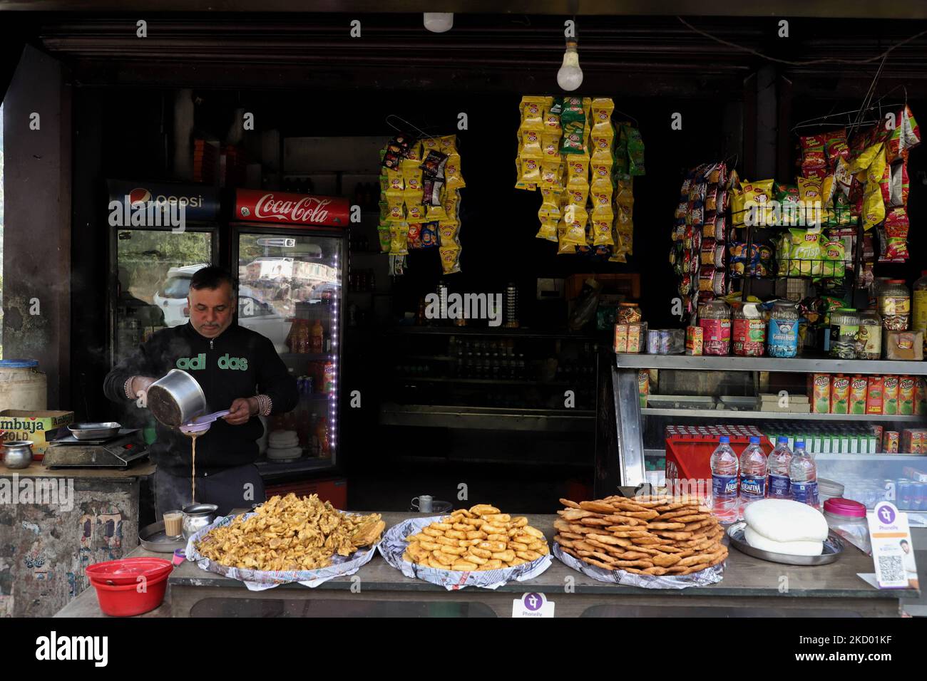 A man prepares tea for customers at his Tea stall in Rajouri, Jammu and ...