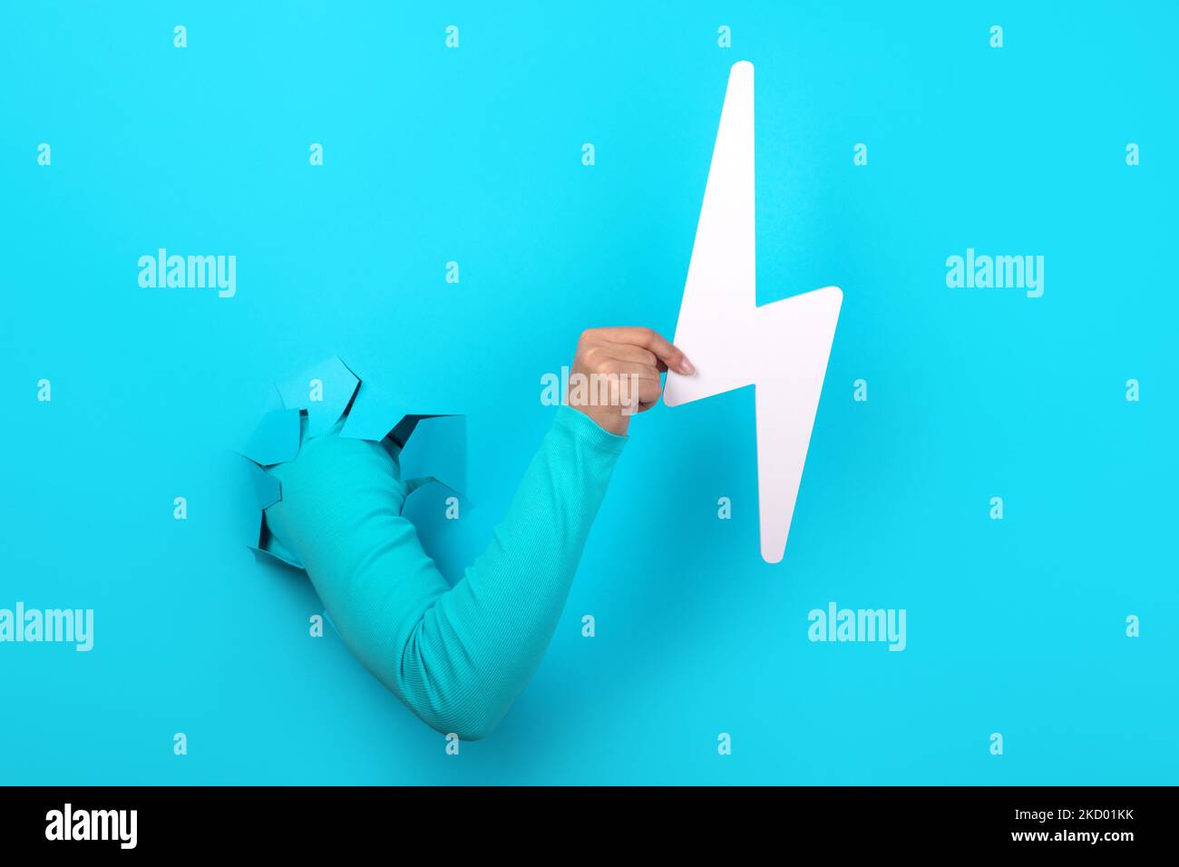 hand holding lightning bolt over blue background Stock Photo - Alamy