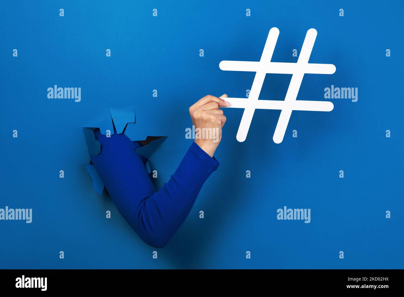 hand holding hashtag sign over blue background, social media concept ...