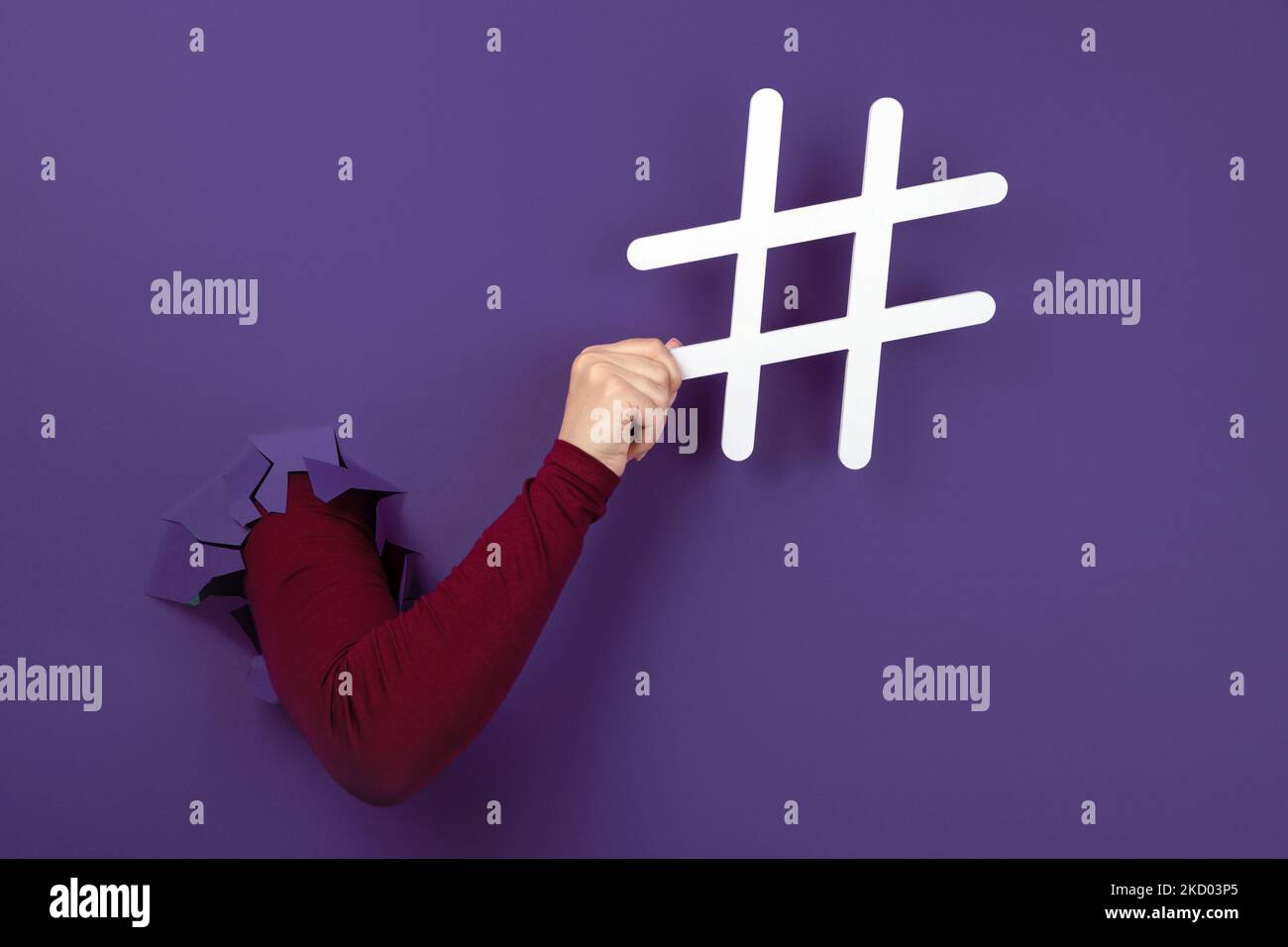 hand holding hashtag sign over purple background, social media concept ...