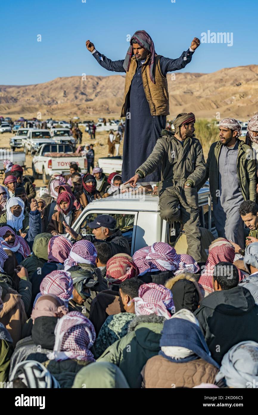 Bedouin man rises his hands discussing with the people for their bets ...