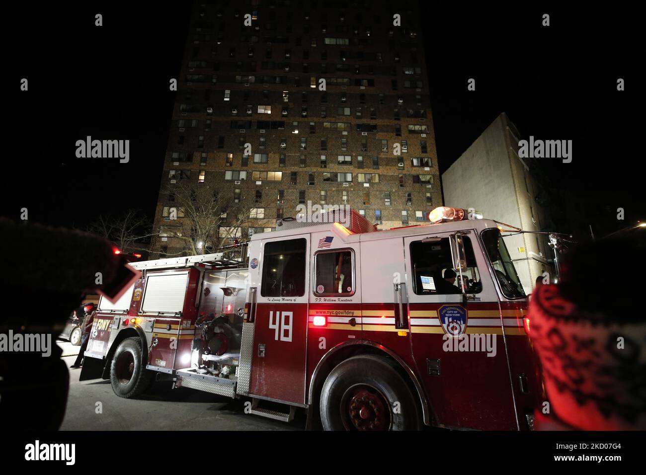 A NYFD fire truck passes in front of the builidng as people attend a ...