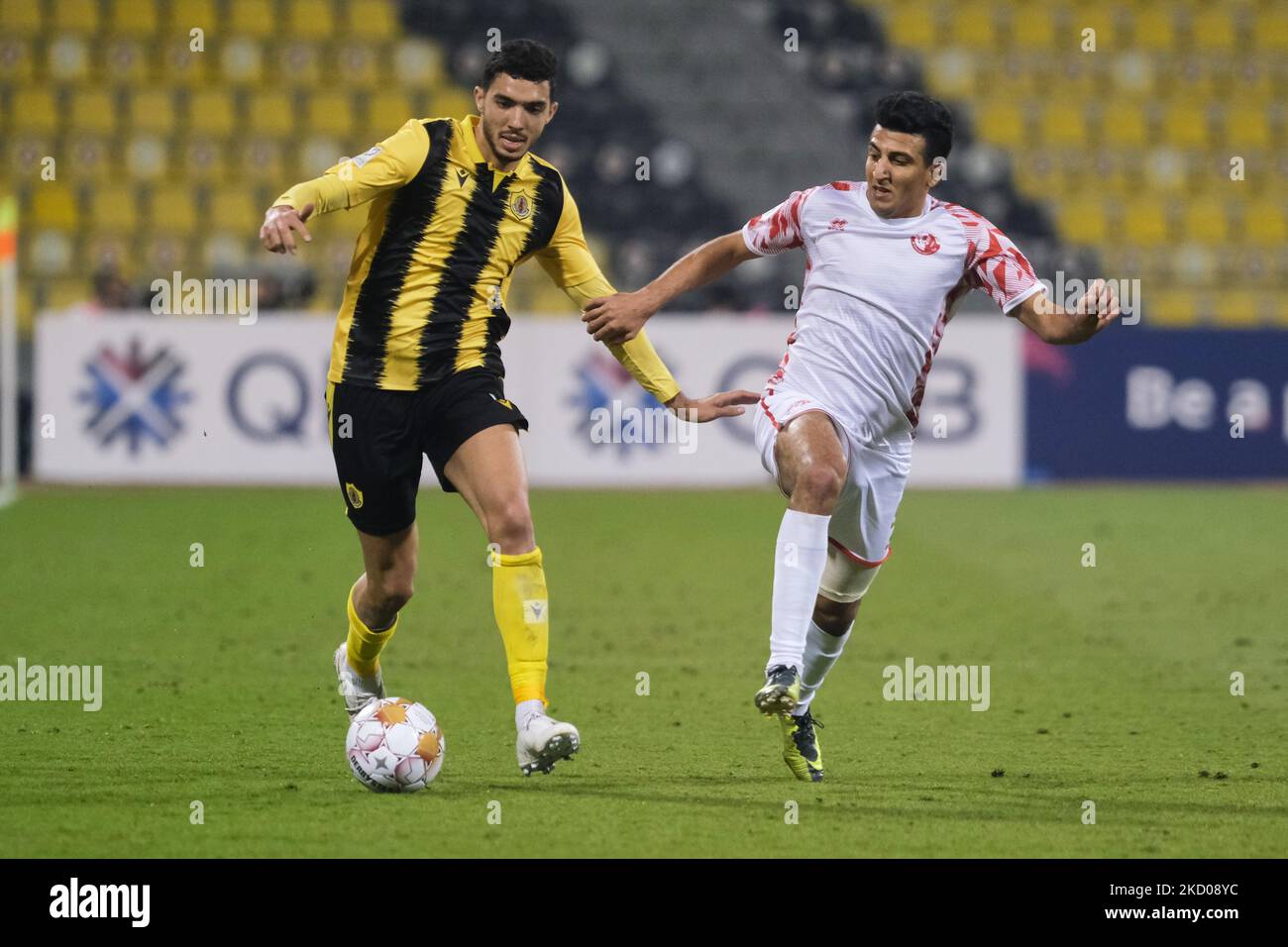 Husam Hassunin (96) of Qatar SC and Amjad Attwan (99) of Al-Shamal ...