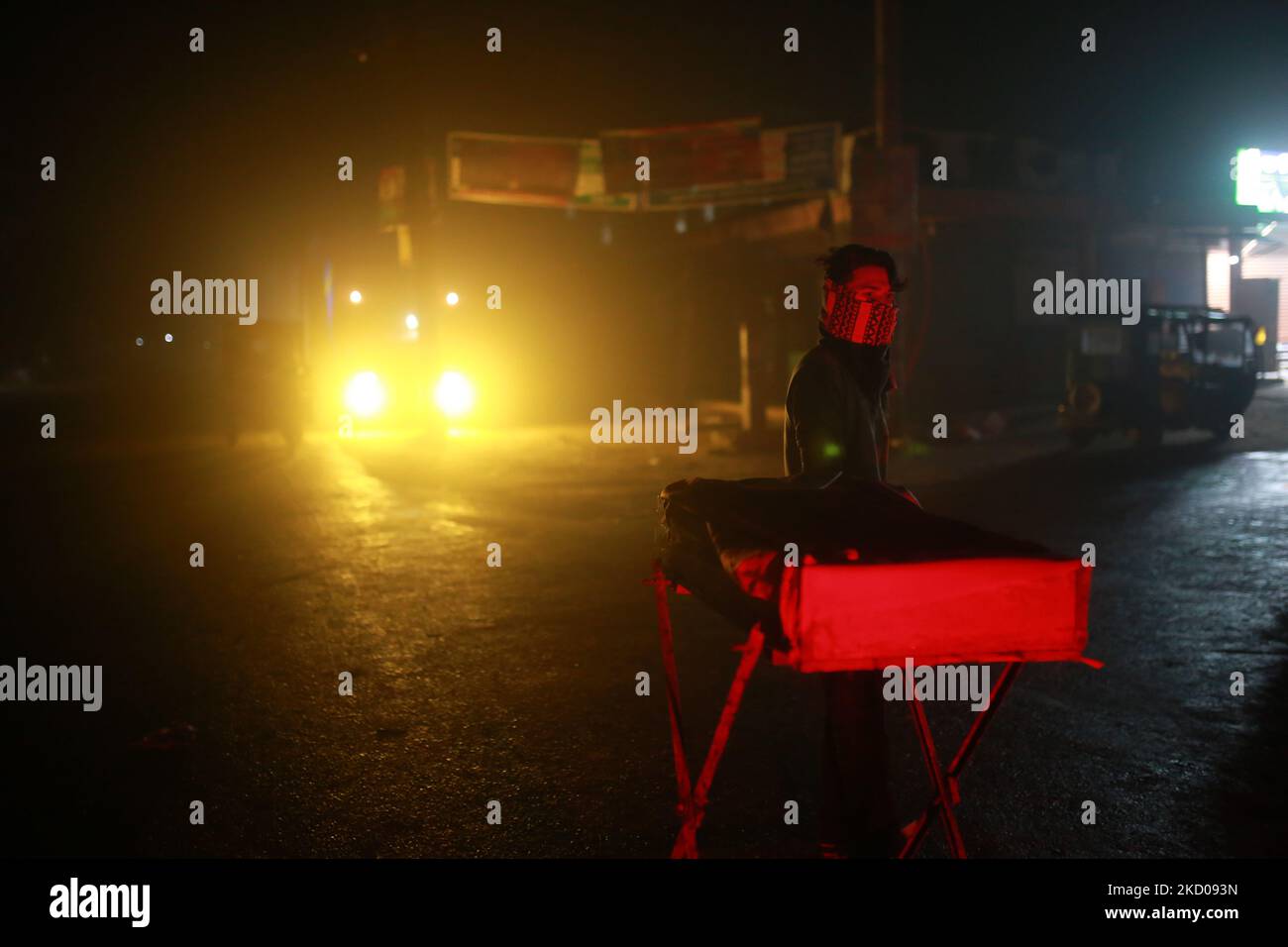 A street vendor waits for customers at night in a rural village in ...
