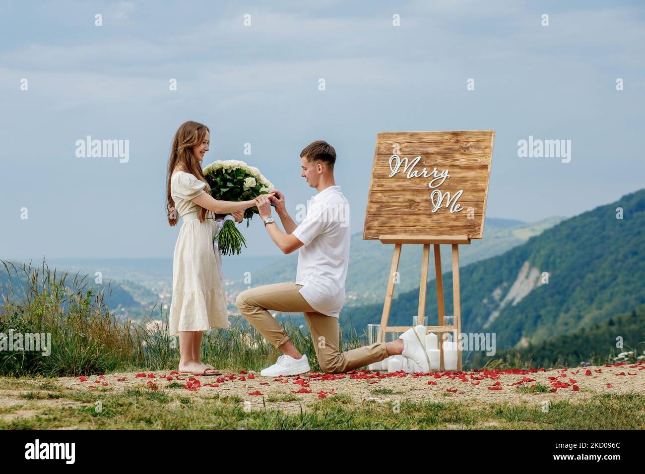 Offer in the mountains. A guy puts a ring on his bride while standing ...