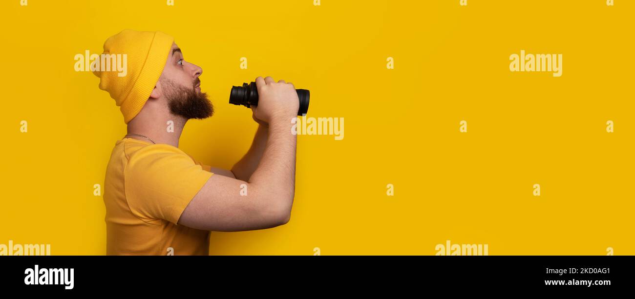 man with binoculars over yellow background, panoramic layout Stock ...