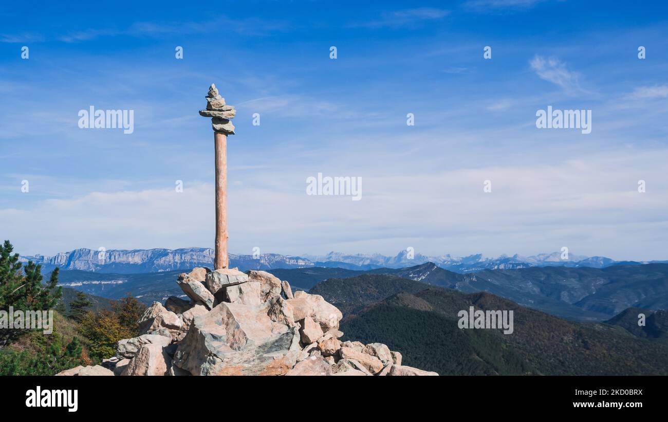 Stone tower with a tree branch on top of a mountain in the alps with a ...