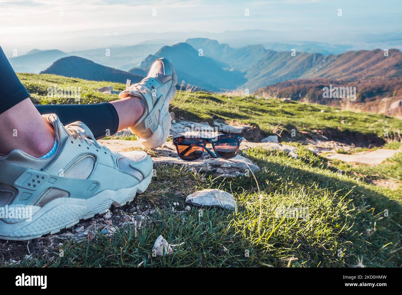 Woman's legs lying on top of the mountain. Rest after reaching the top ...