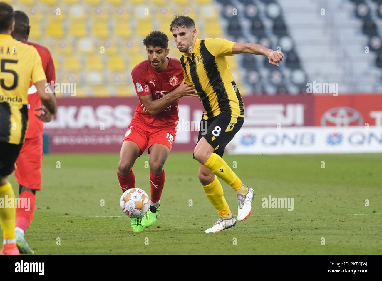 Javi Martinez (8) of Qatar SC and Jassem Gaber (15) of Al Arabi in ...