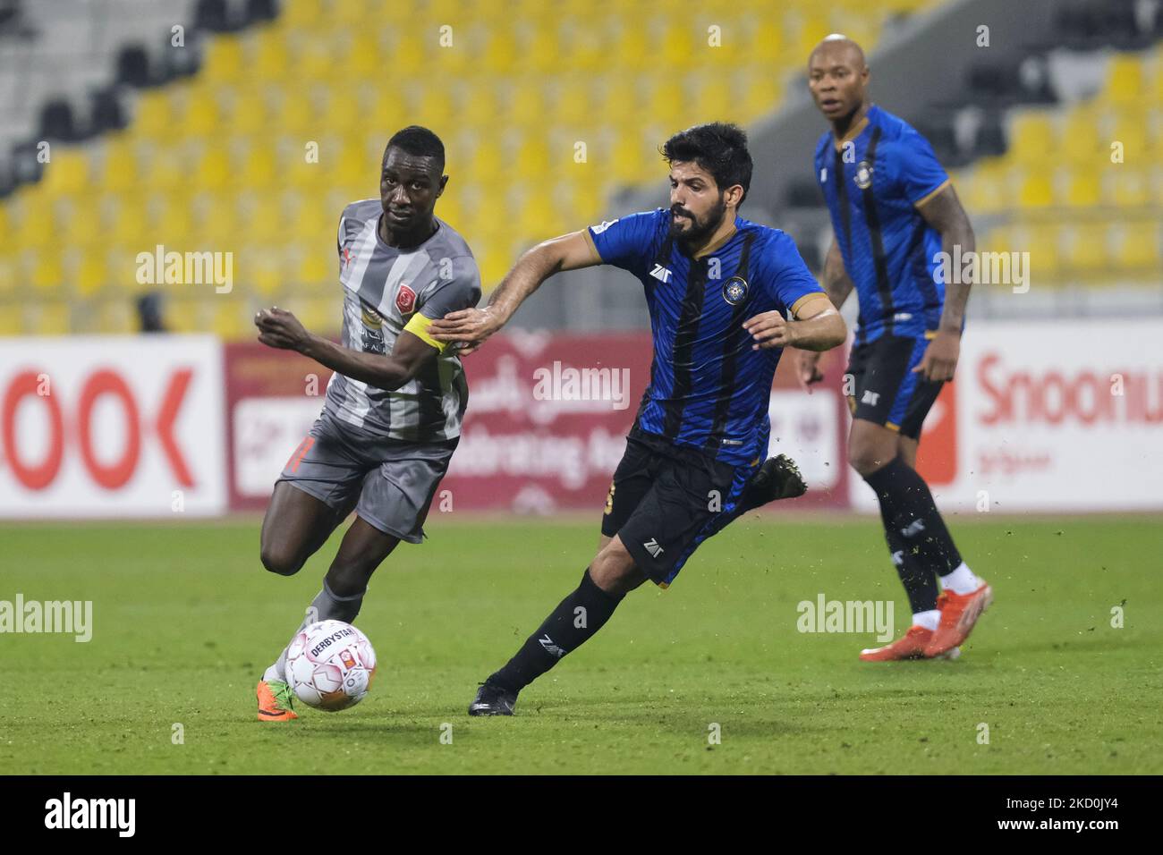 Almoez Ali (11) of Al Duhail and Ghanem Haddaf (6) battle for the ball ...