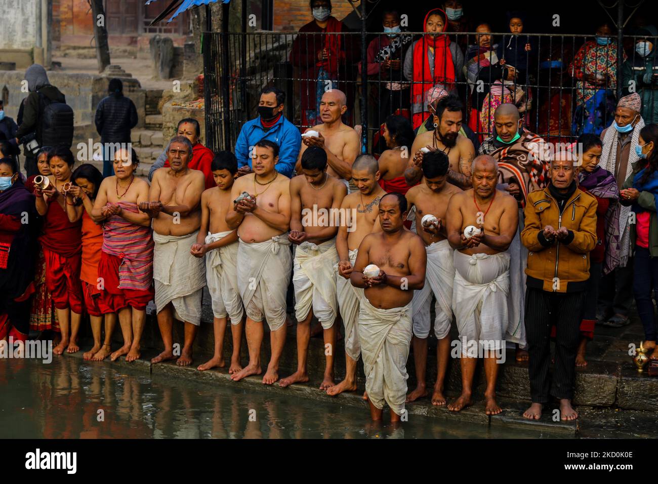 Hindu devotees perform a ritual on the bank of the Hanumante River ...