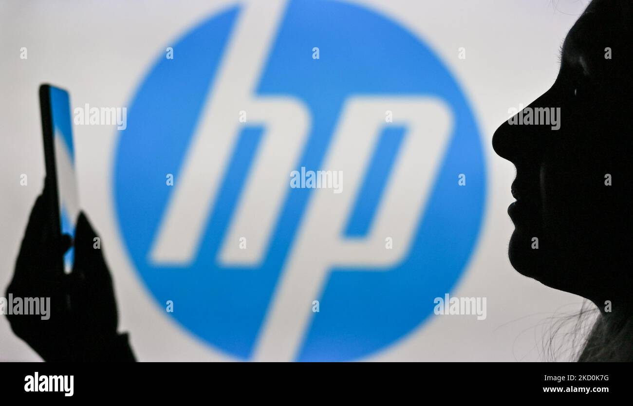 An image of a woman holding a cell phone in front of the Hewlett ...