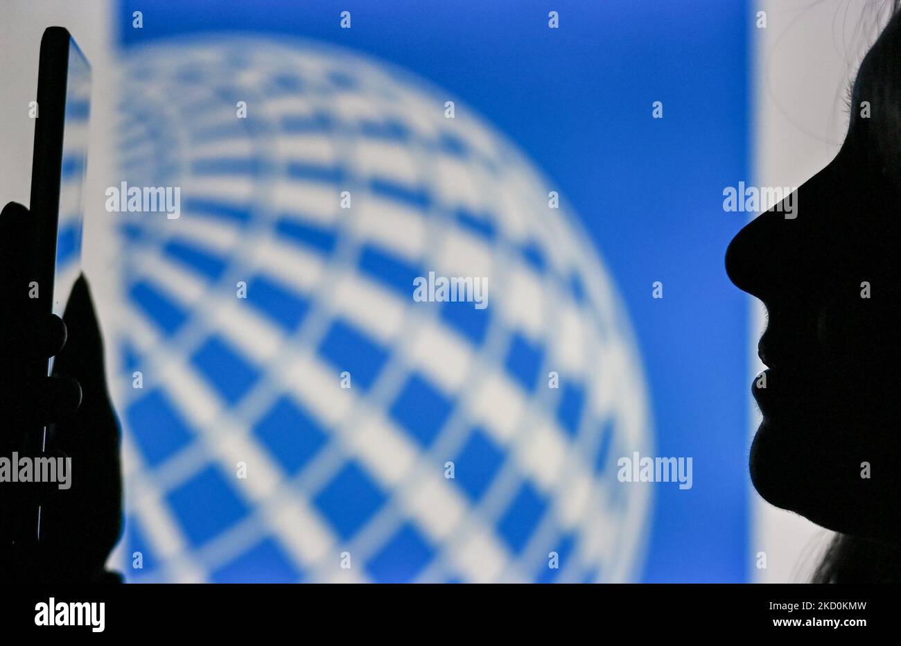 An image of a woman holding a cell phone in front of the United ...