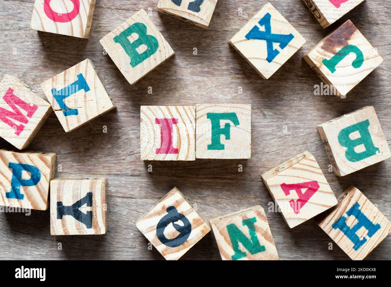 Alphabet letter block in word if and another letter on wood background ...