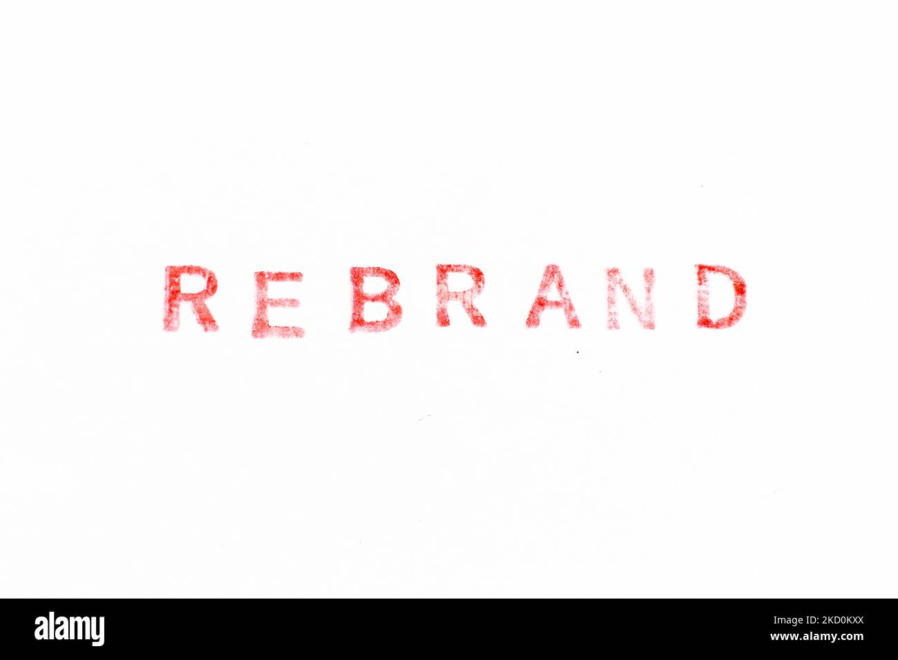 Red color ink rubber stamp in word rebrand on white paper background ...