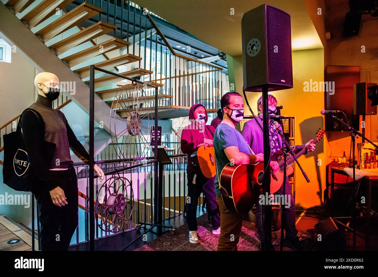 A group of musicians is posing for the press with their mouths covered ...
