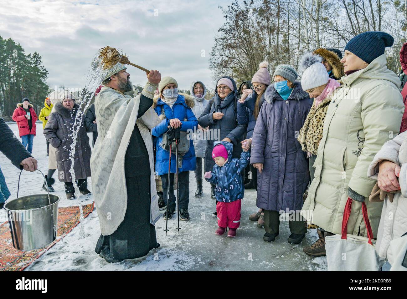 Orthodox priest blesses with holy water to the people in the ...