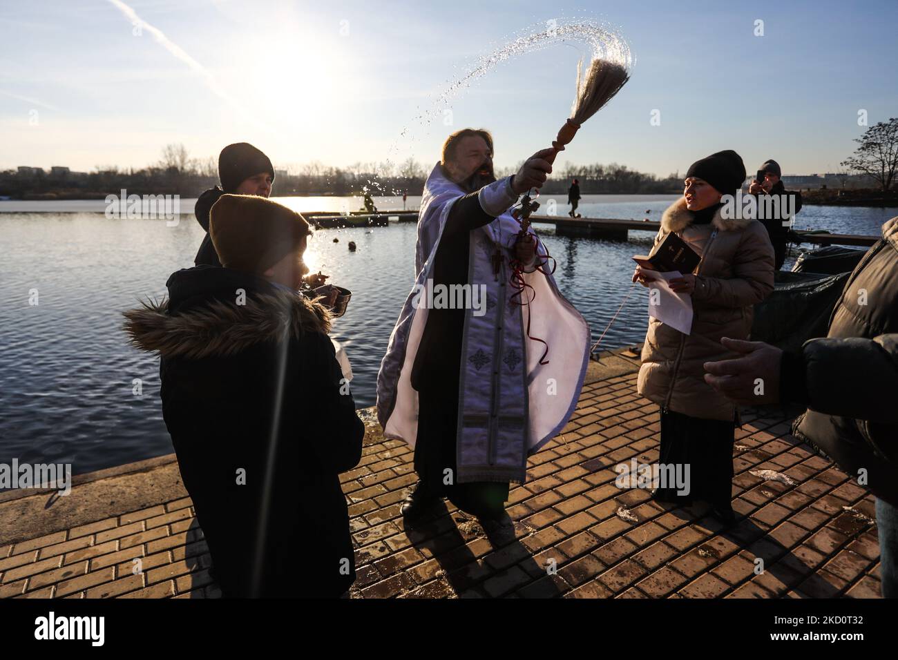 A priest of the Eastern Orthodox Church blesses water during the ...