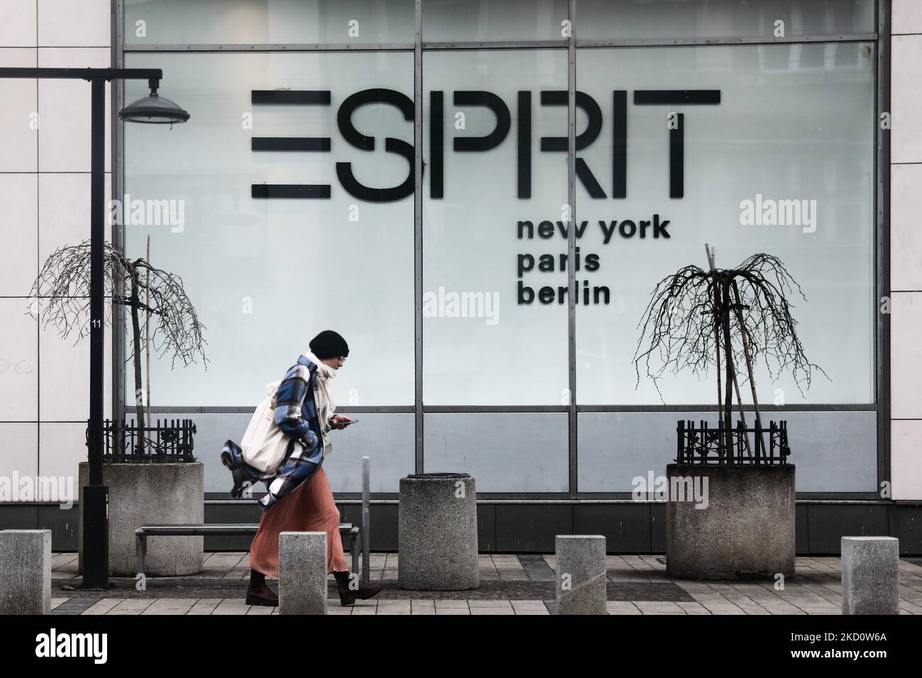 A woman walks by Espirit logo near the shopping mall in Krakow, Poland ...