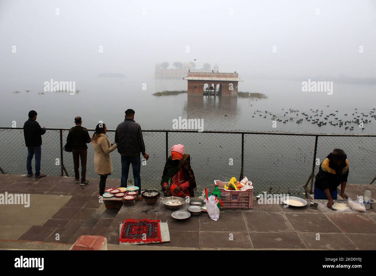 People during a thick layer of fog engulfs the historical Jal Mahal on ...