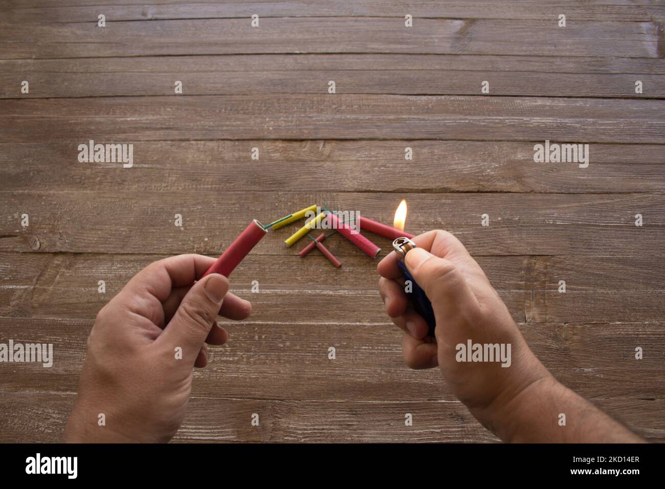 Image of the hands of a man who lights the fuse of a firecracker with a ...