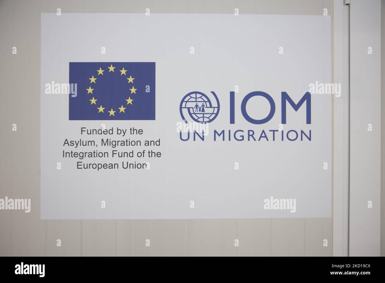 A sign with the IOM UN MIGRATION logo. Inside the new Refugee camp in ...