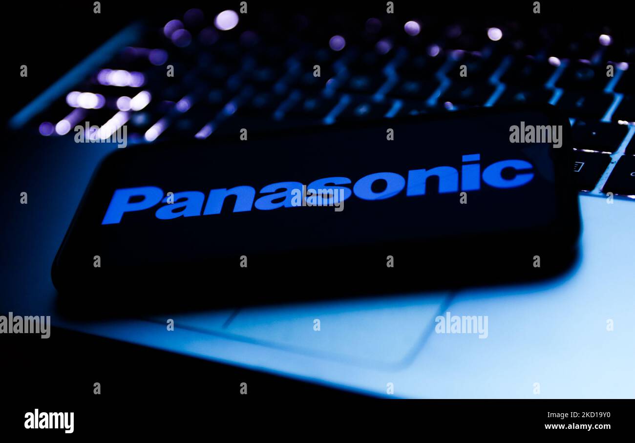 Panasonic logo displayed on a phone screen and a laptop keyboard are ...