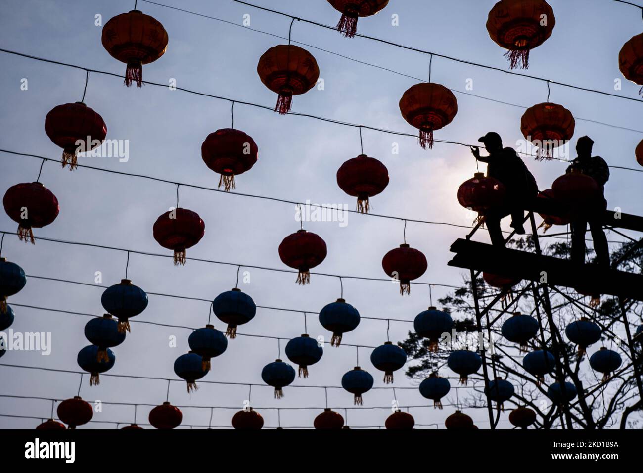 A worker installs a lanterns during welcoming For Lunar New Year at ...