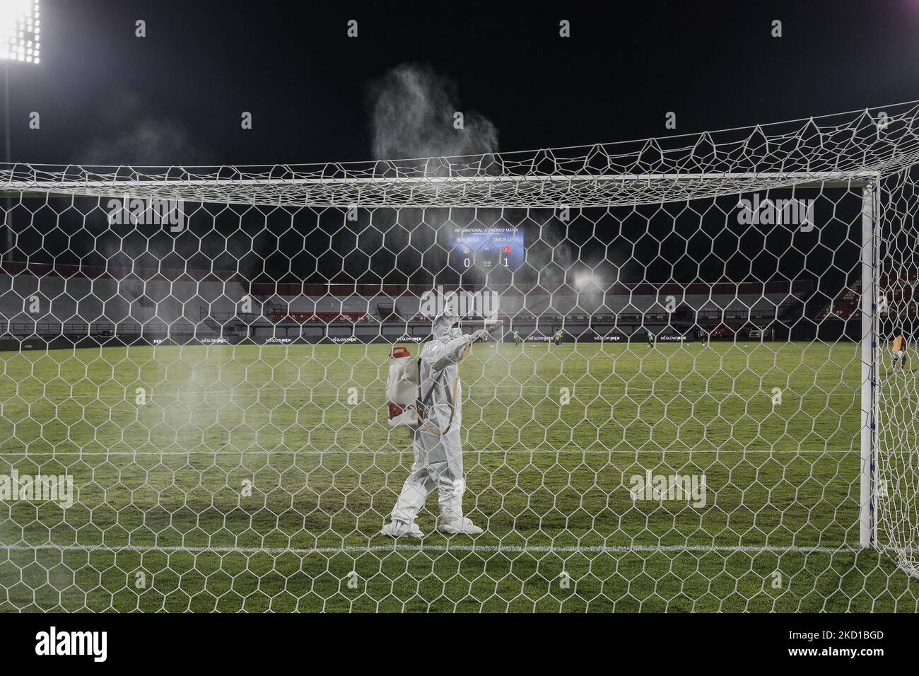 Workers sprays disinfectant to a goal net and bar during half time of ...