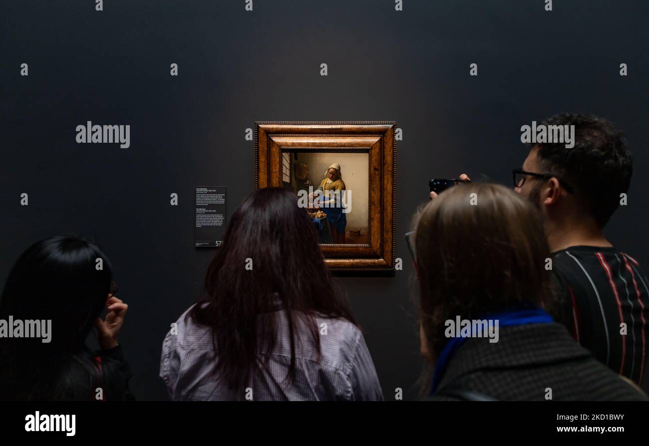 A picture of people watching The Milkmaid painting, by Johannes Vermeer ...