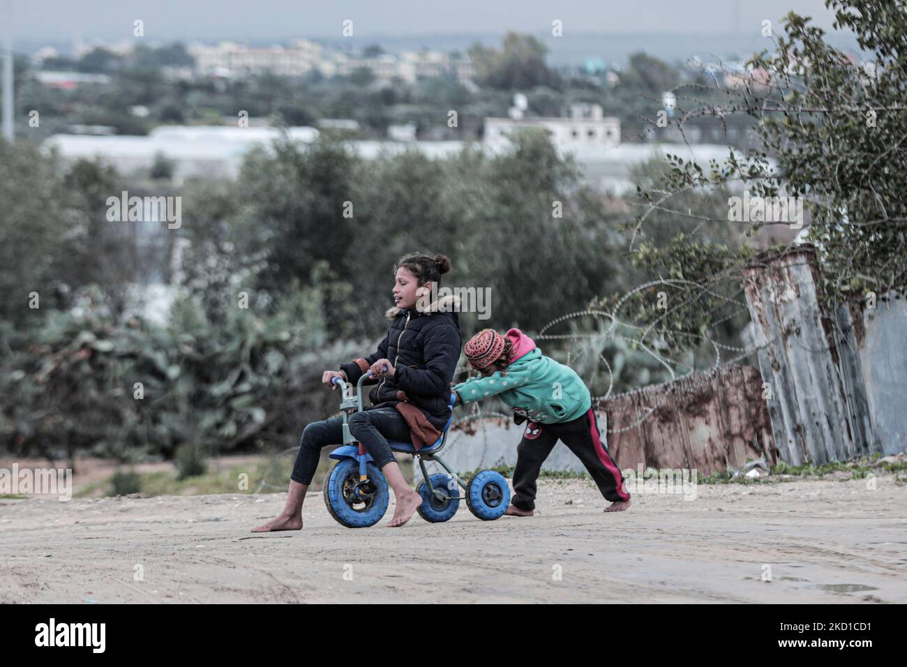 Palestinian children living in slums play in the street during cold ...