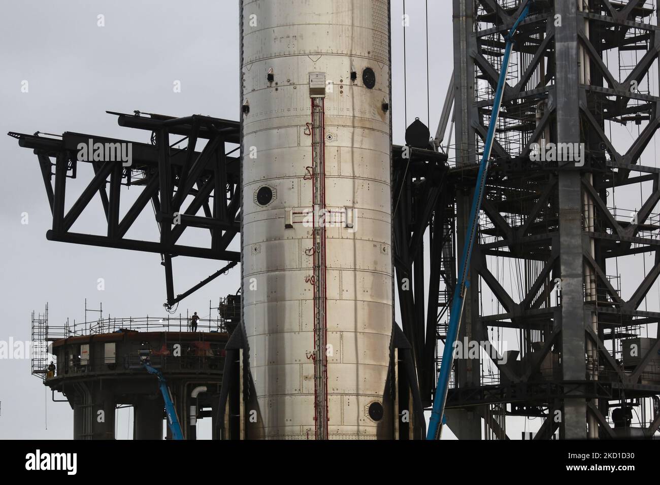 A man is seen standing on the orbital launch table behind Starship 20 ...