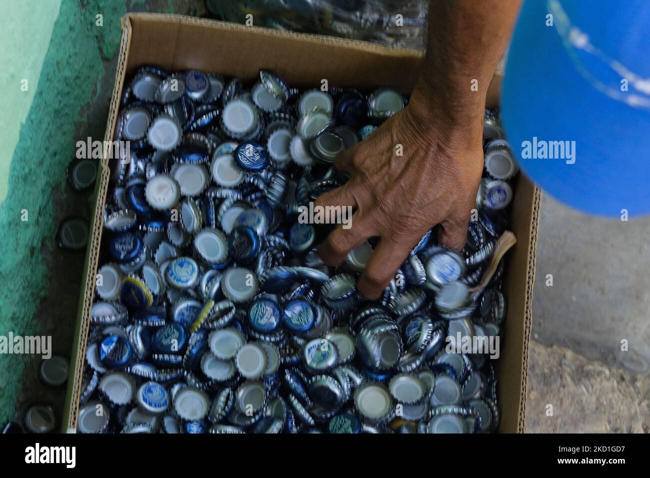 A man holds chapas during a traditional baseball-inspired game, called ...
