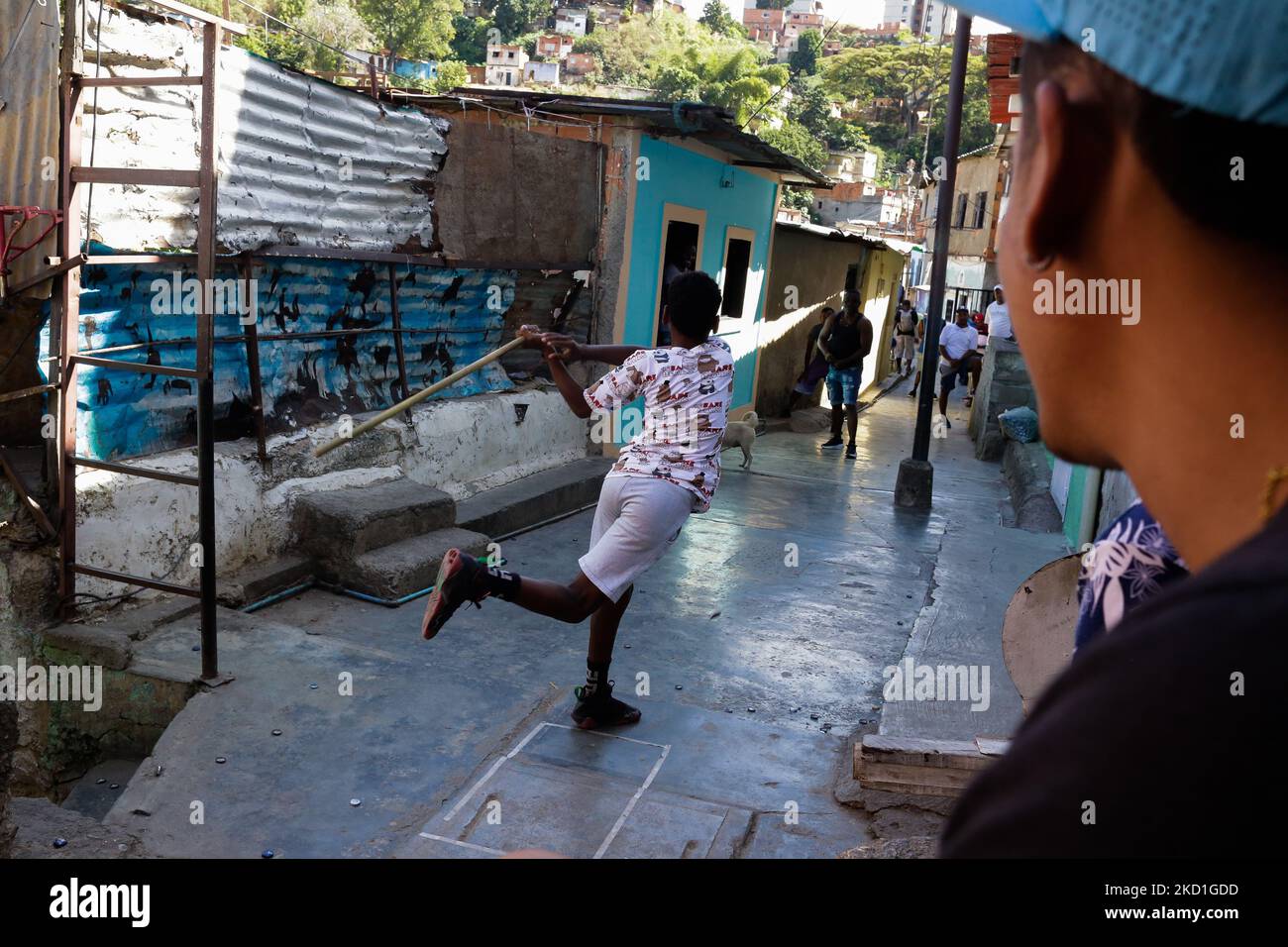 A boy bats during a traditional baseball-inspired game, called Chapitas ...