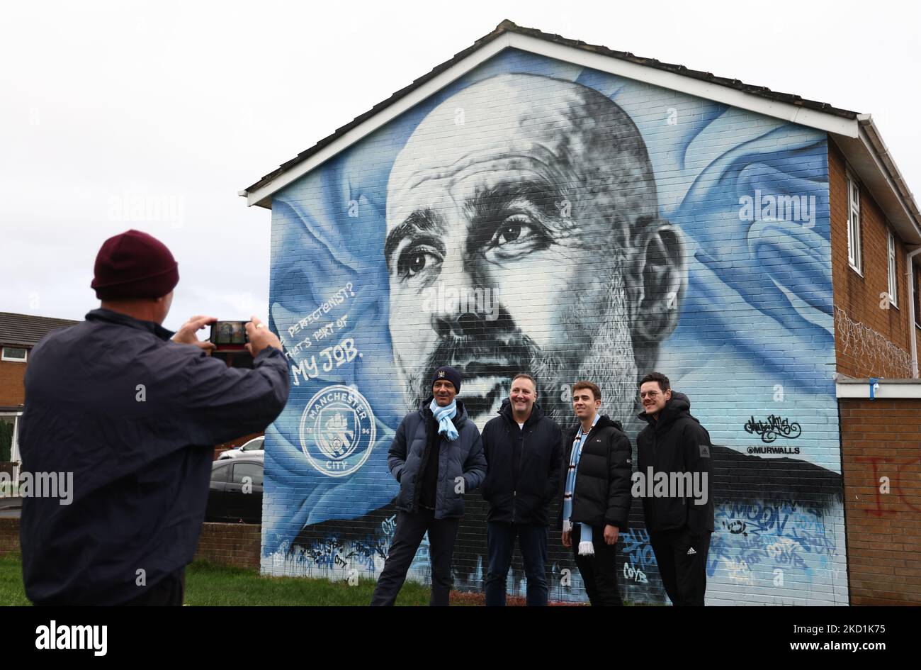 Manchester, UK. 5th November 2022. Fans pose in front of a mural of ...