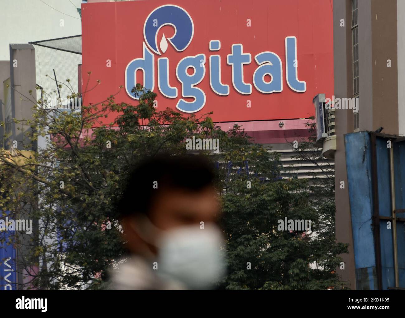 A man walks past a Reliance Jio logo in Kolkata, India, 31 January ...